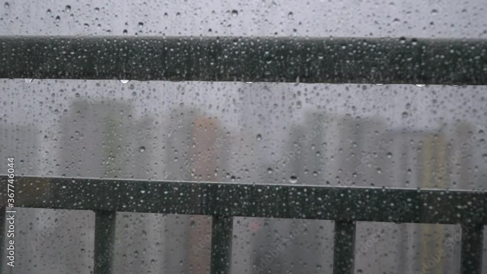 Water droplets on transparent window with skyscrapers in background ...