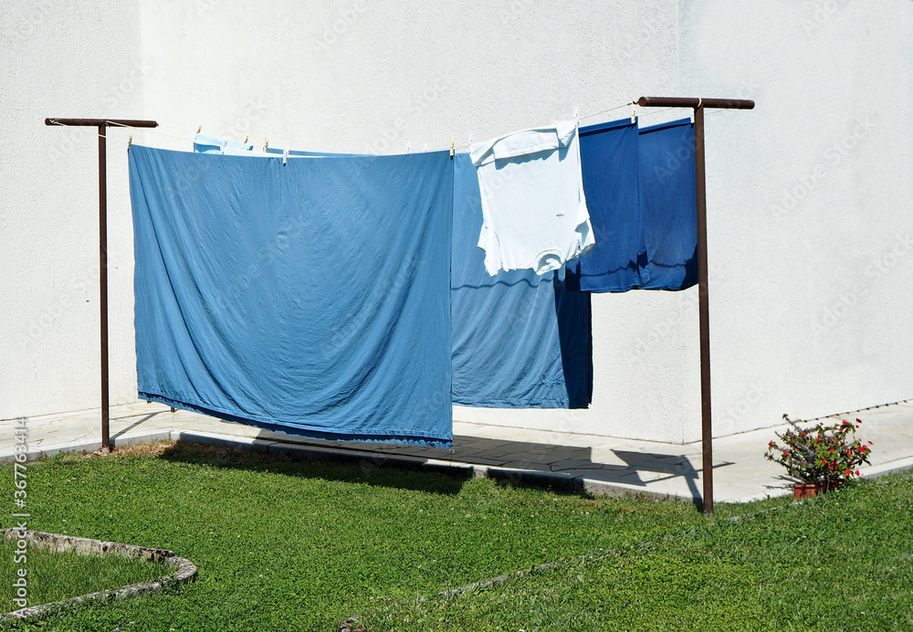 Blue sheets and white laundry hanging out to dry on the fixed drying ...