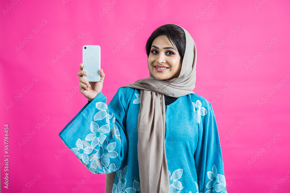 Beautiful woman from Dubai posing on colored background with ...