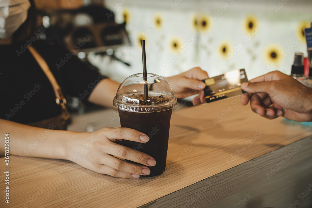hand customer paying with credit card for buying ice black coffee on ...