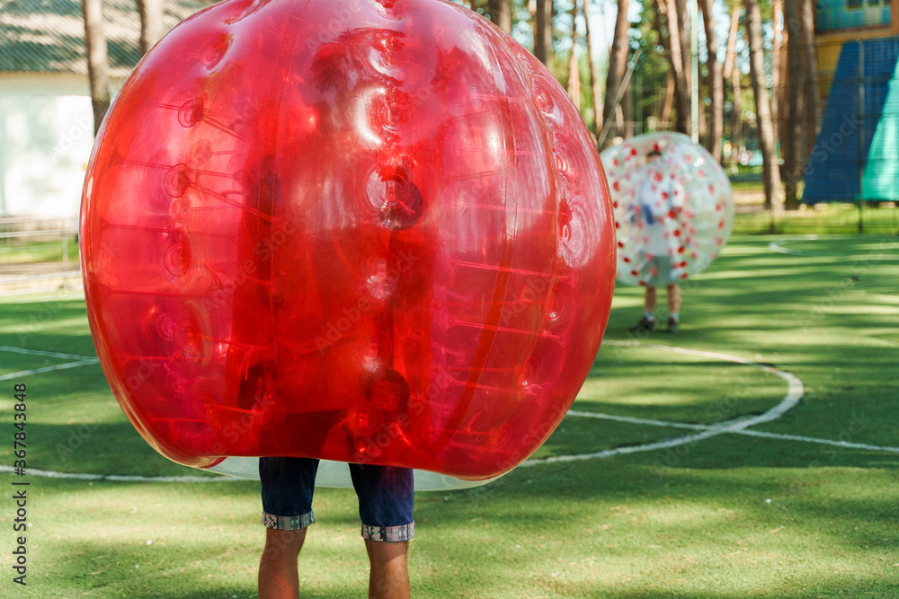 Foto de Bubble football sport game. Football players play bumperball on ...