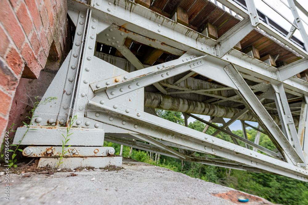 Old riveted steel bridge over the river. River crossing for the ...