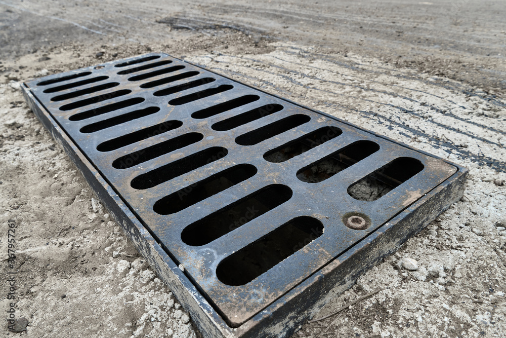 New rainwater grate on the road or sidewalk, installation in concrete ...