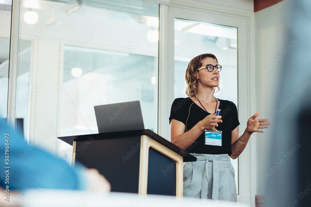 Businesswoman public speaking behind the podium Stock Photo | Adobe Stock