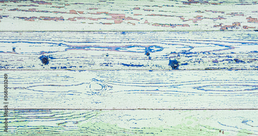 Old wood paneling. Peeled paint in mint and blue. Cracks and chips ...