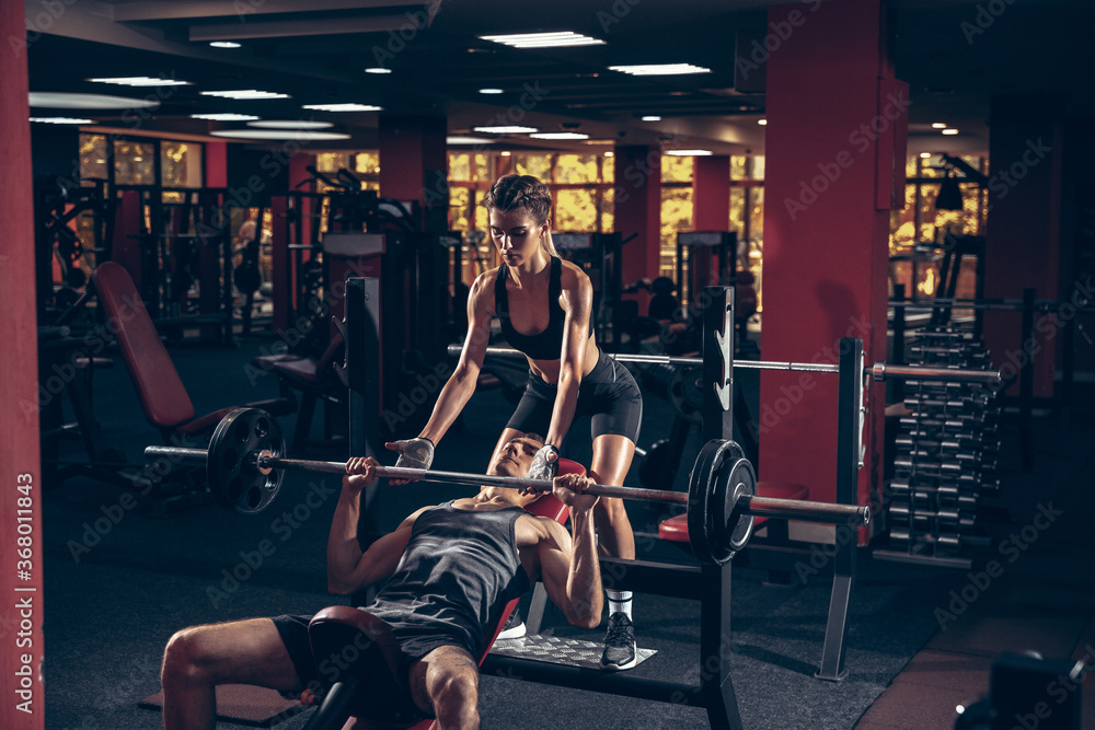Beautiful young sporty couple workout in gym together. Caucasian man ...