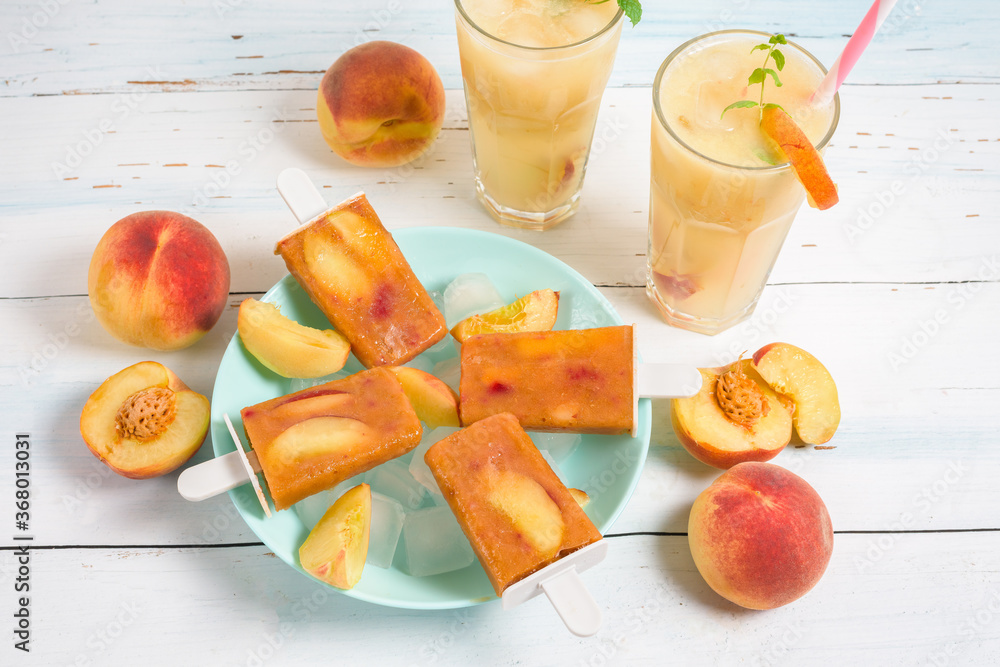 peach ice cream on a stick in a blue plate and ice cubes, peach ...