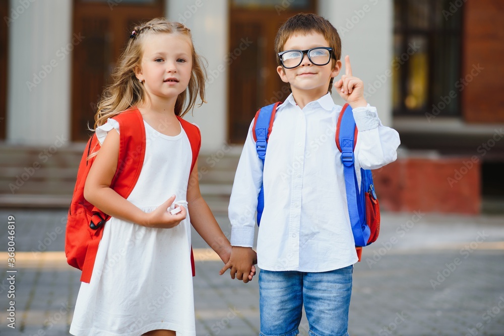 Happy children - boy and girl with books and backpacks on the first ...