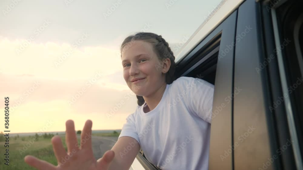 happy girl kid child leaned out of a car lifestyle window waving hand ...