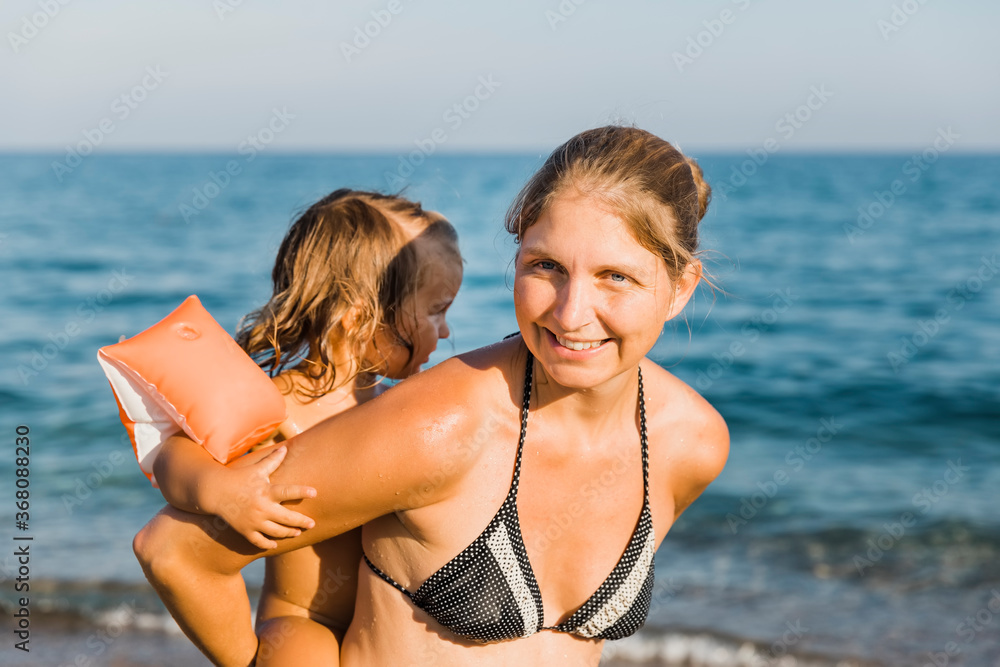 Mother carrying daughter piggyback on beach Stock Photo | Adobe Stock Mother carrying daughter piggyback on beach Stock Photo | Adobe Stock