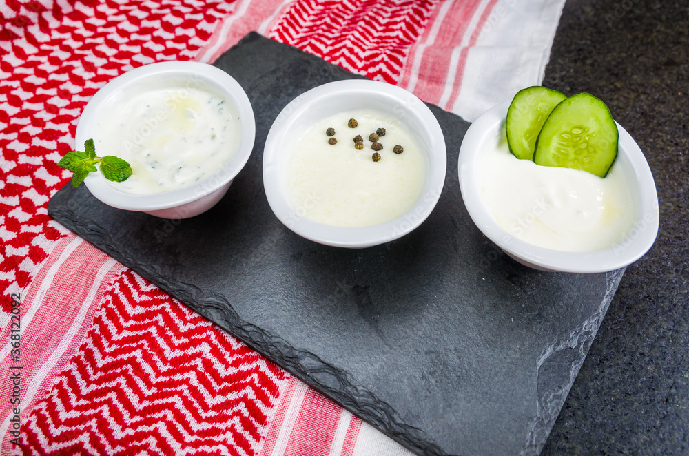 Delicious Lebanese food, thum, labneh and tzatziki sauces on black ...