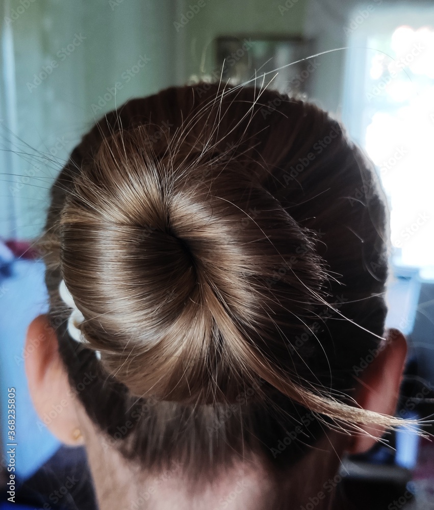 beautiful female hairstyle, a bump of hair on the head, hair tied in a ...