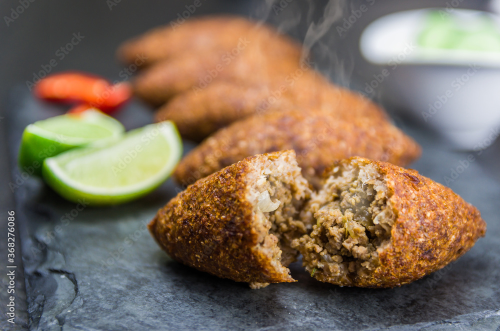 Delicious Lebanese (Arabic) food, kibbeh (kibe) on black slate stone ...