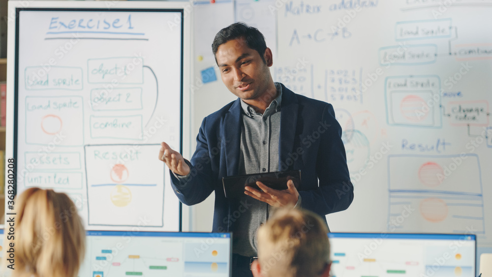 Elementary School Class: Teacher Uses Interactive Digital Whiteboard, Explains Lesson to Diverse ...