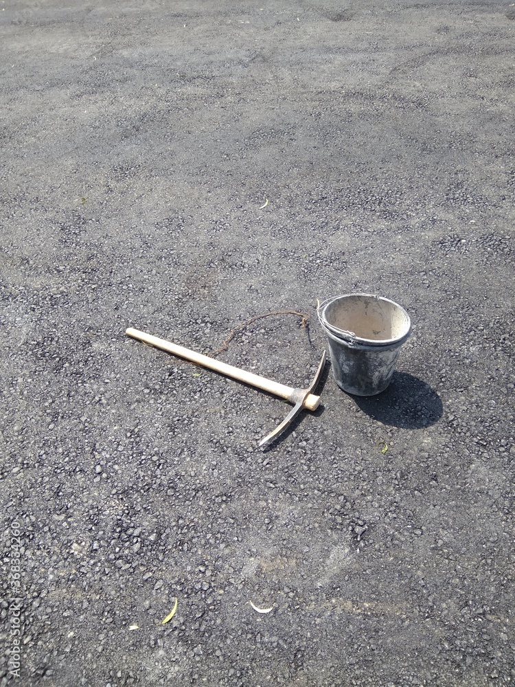 Working tools bucket and pickaxe when paving asphalt. Stock Photo ...