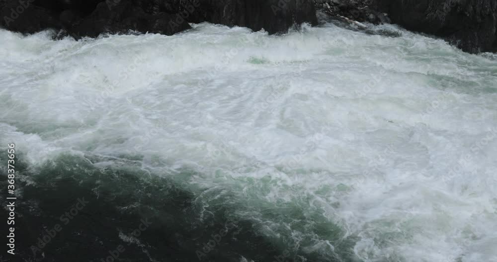 Streaming current wit foam in mountain river near damaged abandoned ...