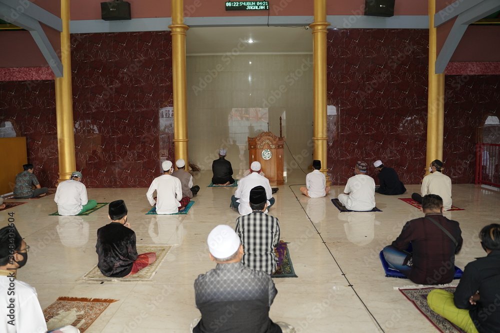 Muslim men are sitting inside the mosque maintaining social distancing ...