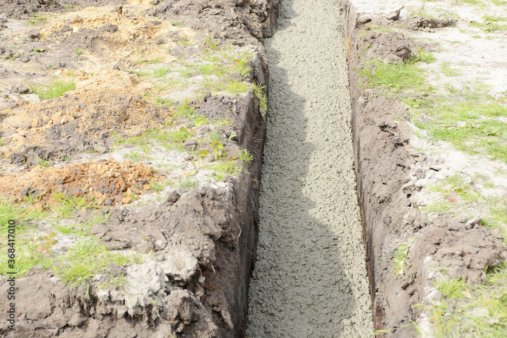 Filling strip foundation with concrete at the construction site. start ...