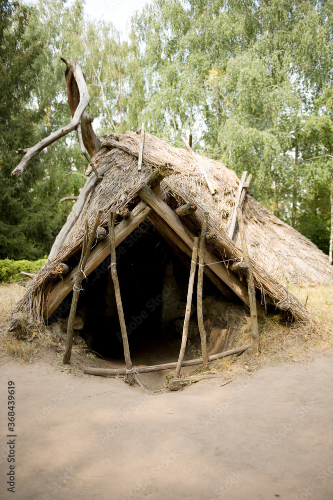 Reconstruction of a hut of a primitive man of the Stone Age, a dugout ...