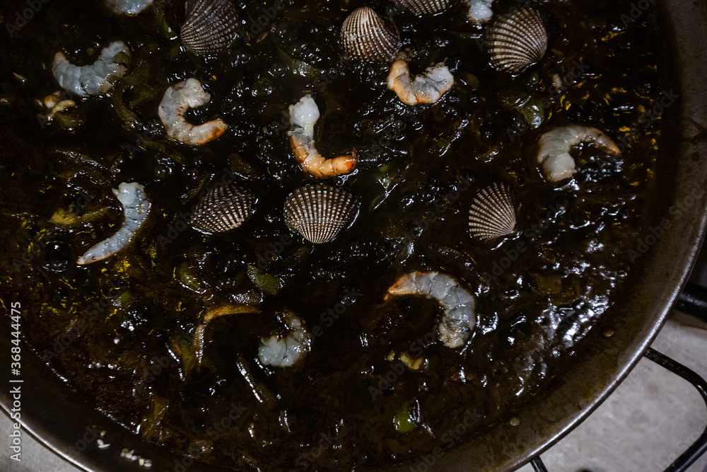 Delicious spanish black squid ink paella with shrimps and scallops ...