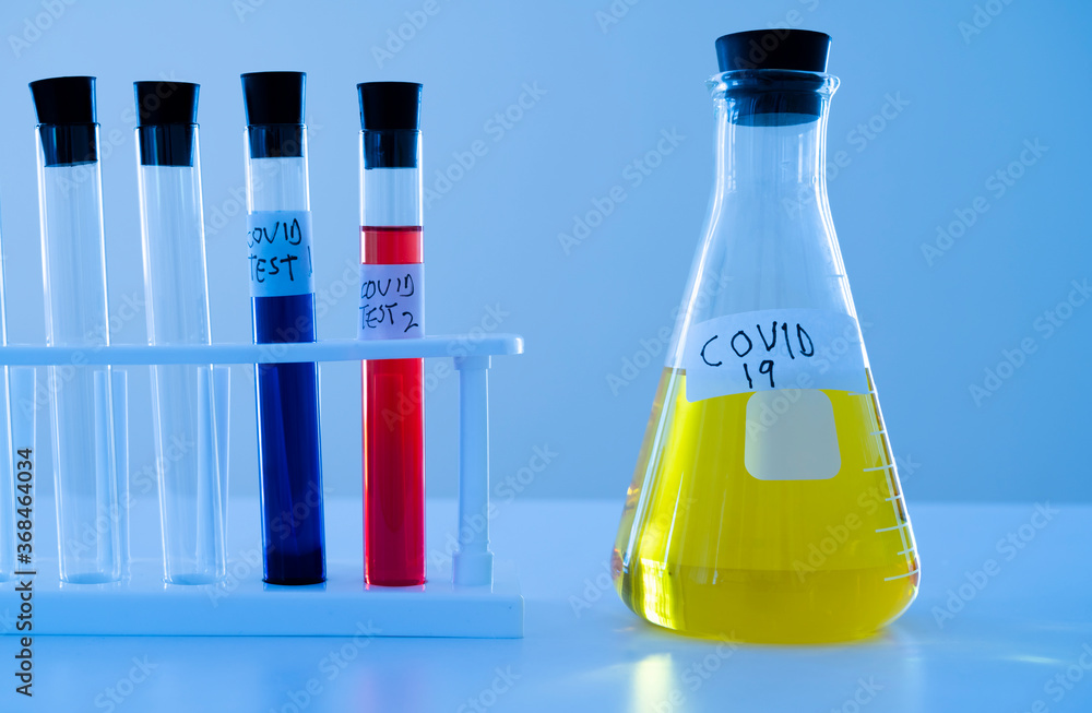 Covid-19 vaccine research. Test tubes and Erlenmeyer flask with colored ...