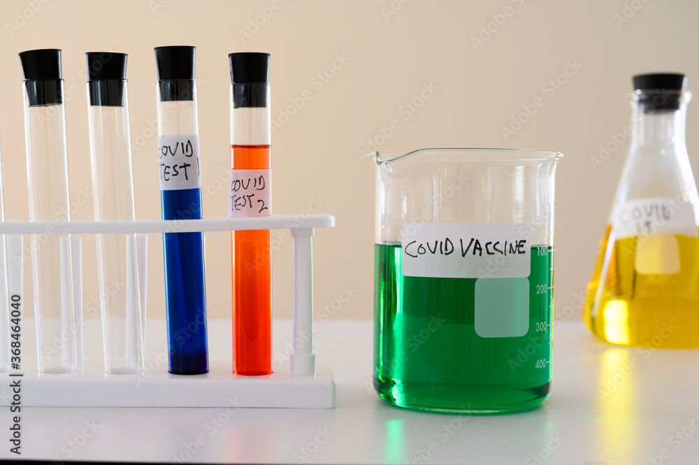 Covid-19 vaccine research. Test tubes, flask and beaker with colored ...