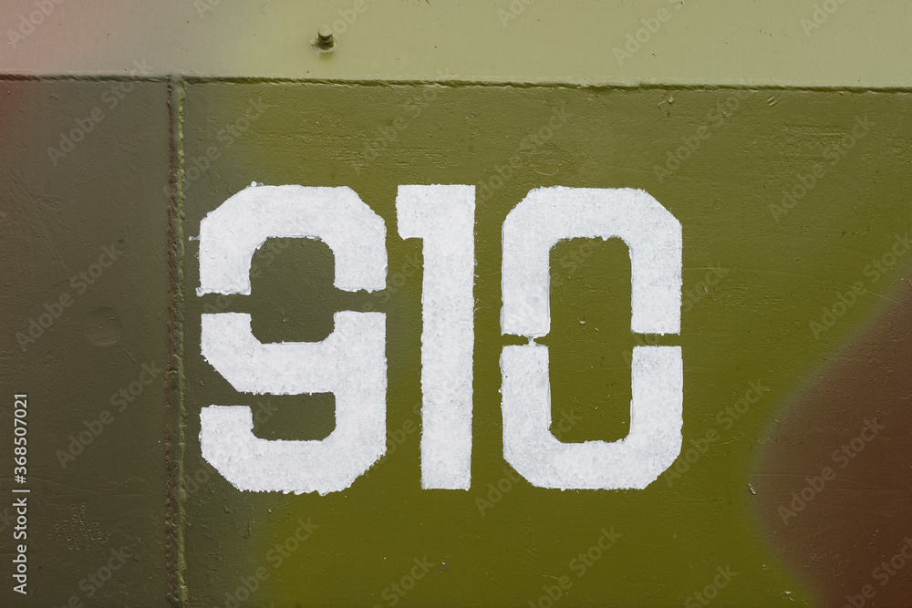 Tactical number on the armor of the tank. Old camouflage surface with ...