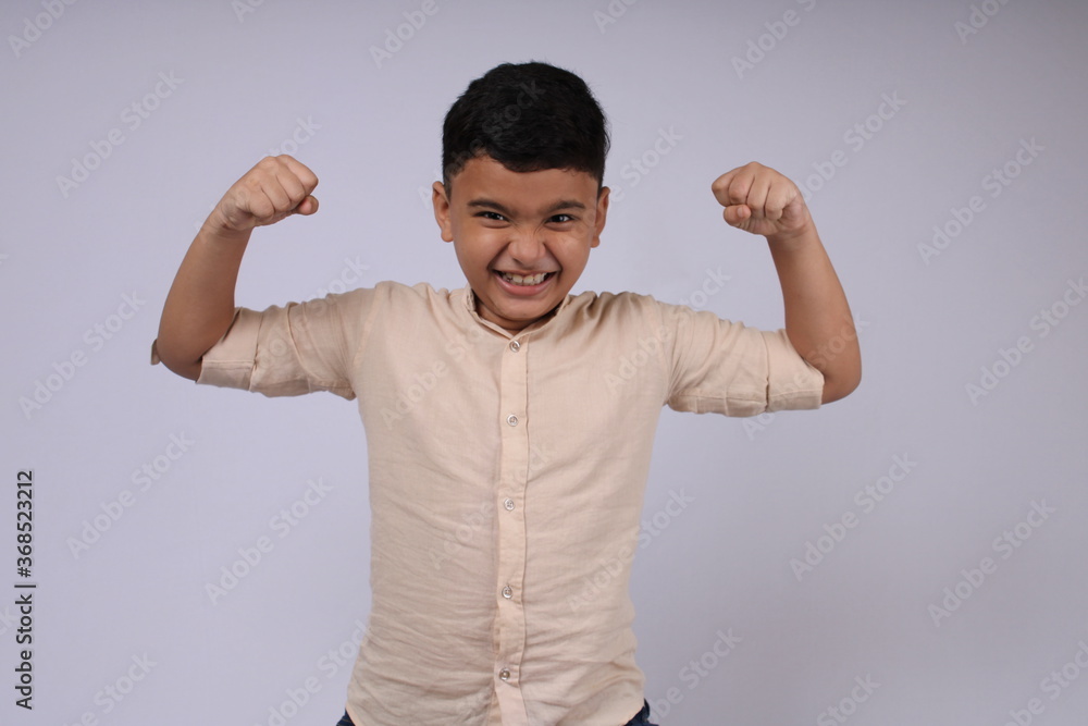 Cute and smart Indian boy displaying pose. Its a front facing photo ...