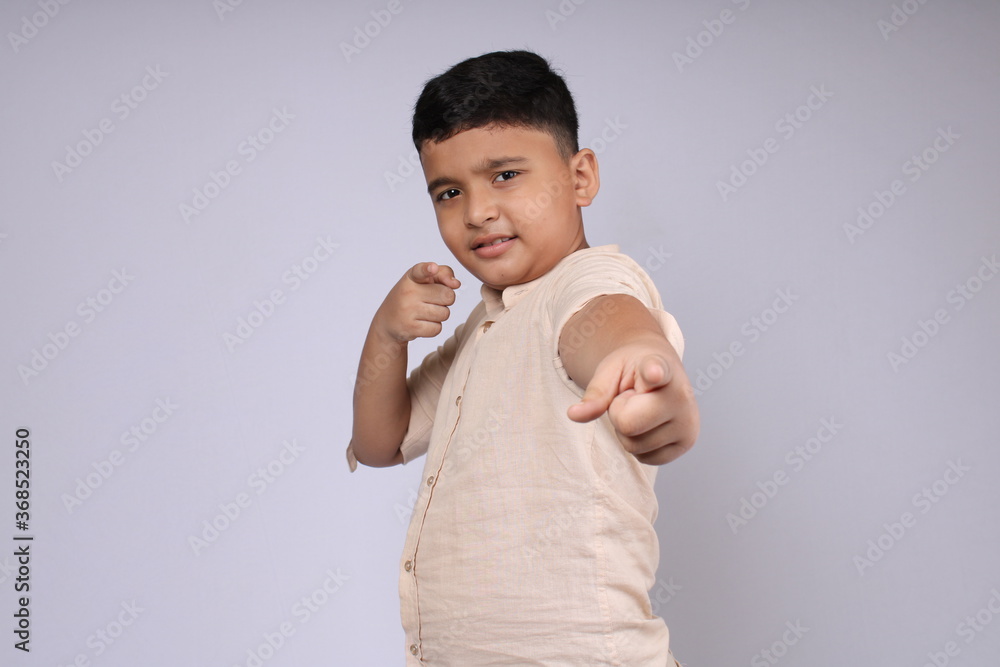 Cute and smart Indian boy displaying pose. Its a front facing photo ...
