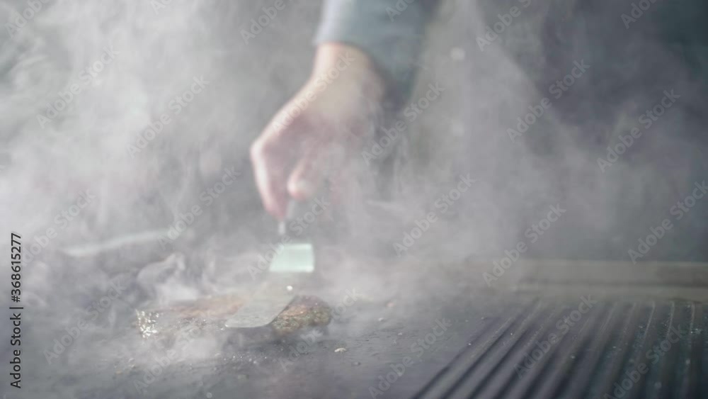 The chef fries a hamburger Patty, fried meat Patty for a Burger, junk ...