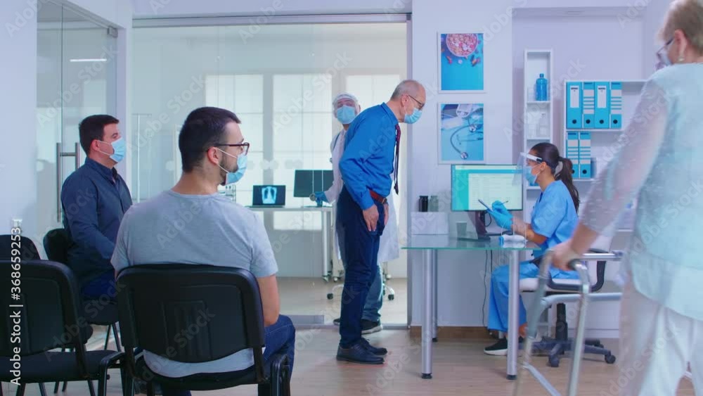 Medic with visor against covid 19 calling patient in consultation room ...
