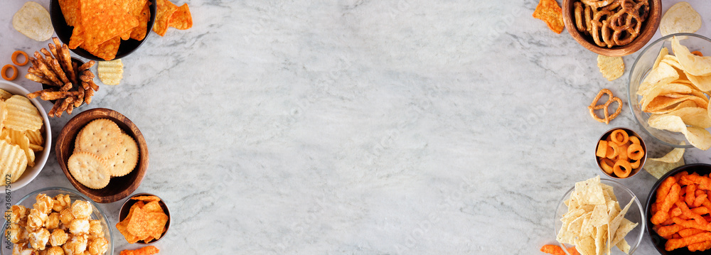 Assorted salty snacks. Double side border with copy space. Top view on ...