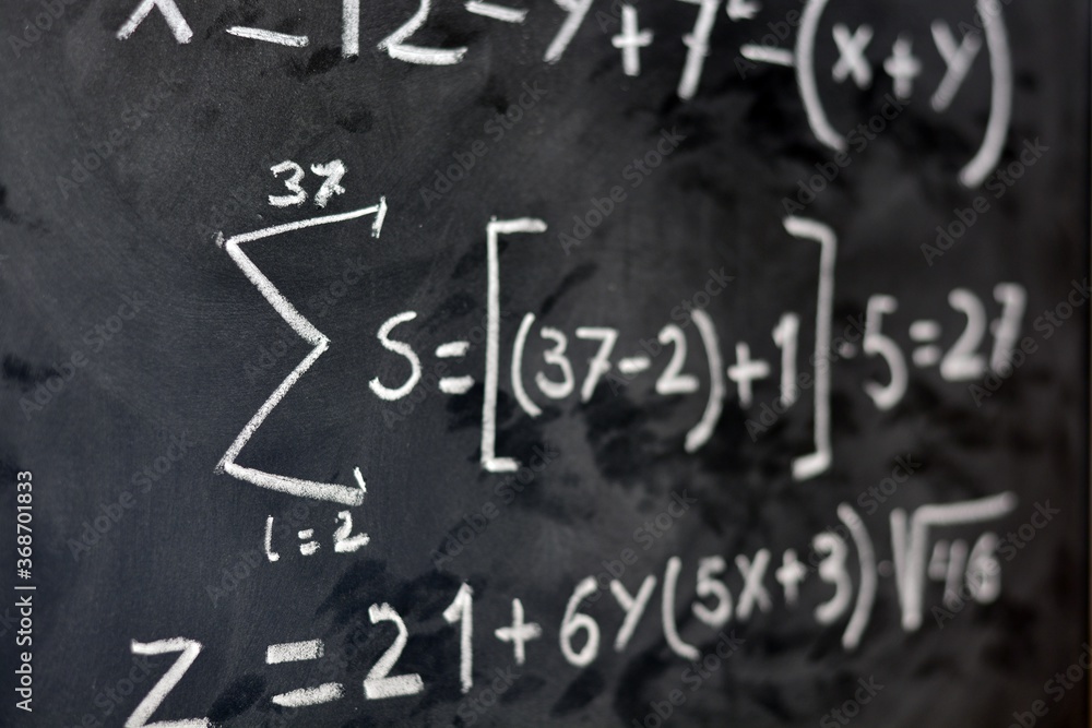 Ecuaciones matemáticas escritas a mano con una tiza blanca en la ...