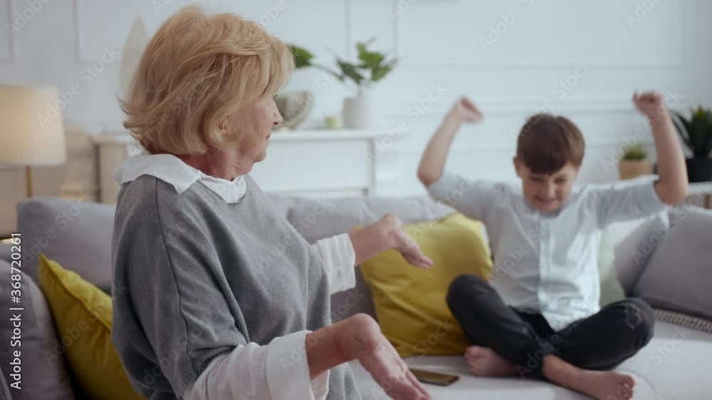 Stockvideo Blonde old grandmother looking after hyperactive energetic ...