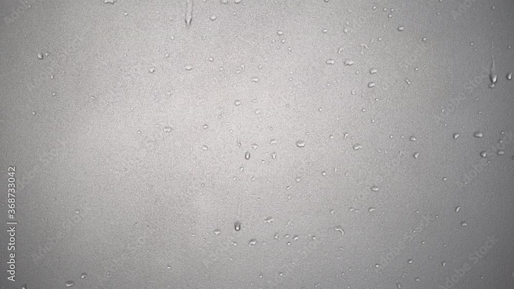 Water droplet on frosted glass wall or wet translucent window from rain ...