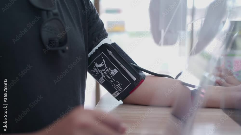 Stockvideon Man patient Measure blood pressure at clinic front desk ...