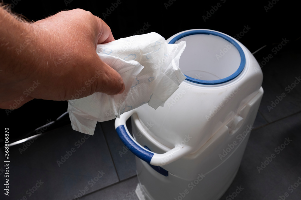 We throw the baby diaper into the waste bin. Rubbish in the trash can ...