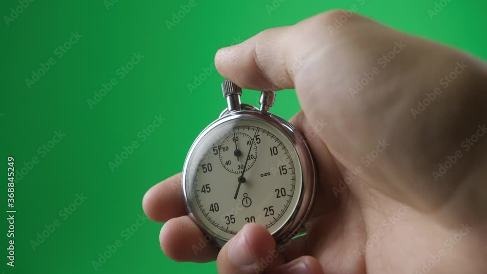 Male hand holding analogue stopwatch on green screen chroma key. Time ...