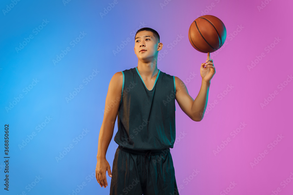 Handsome. Young basketball player confident posing with ball on ...