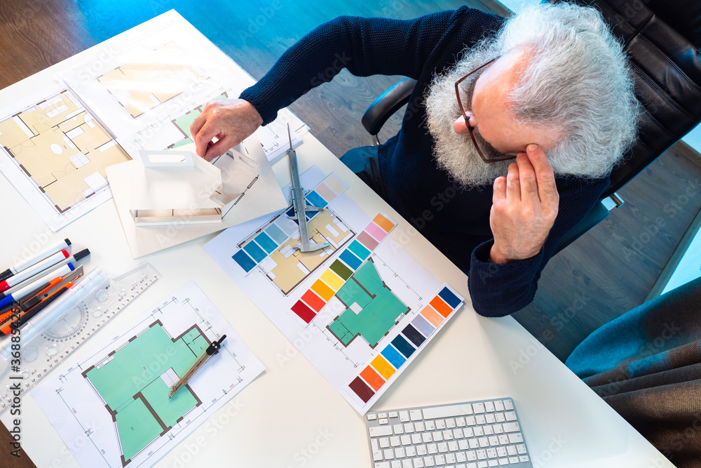 Interior designer at work. A gray-haired architect at his Desk. The man ...