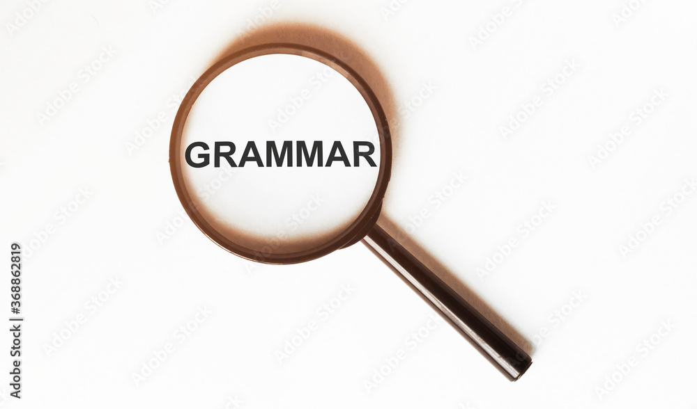 Grammar on a sheet under a magnifying glass Stock Photo | Adobe Stock
