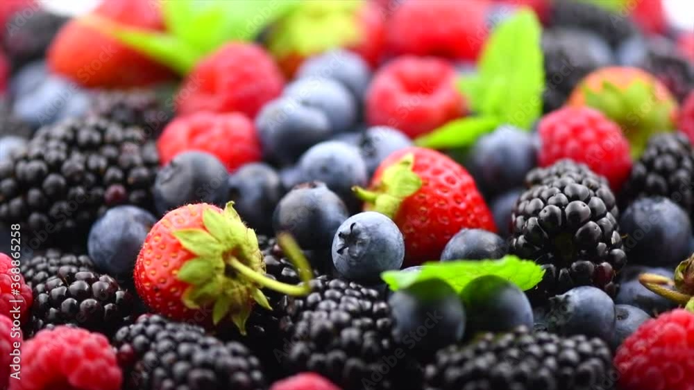 Berries. Various colorful berries rotation background. Mint leaves ...