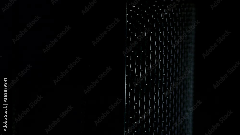 Microphone grid surface spinning around. Extreme close-up footage of ...