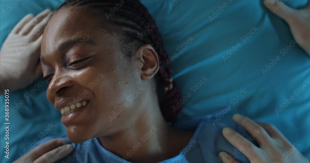 Young scared woman crying while lying on hospital stretcher. Top view ...