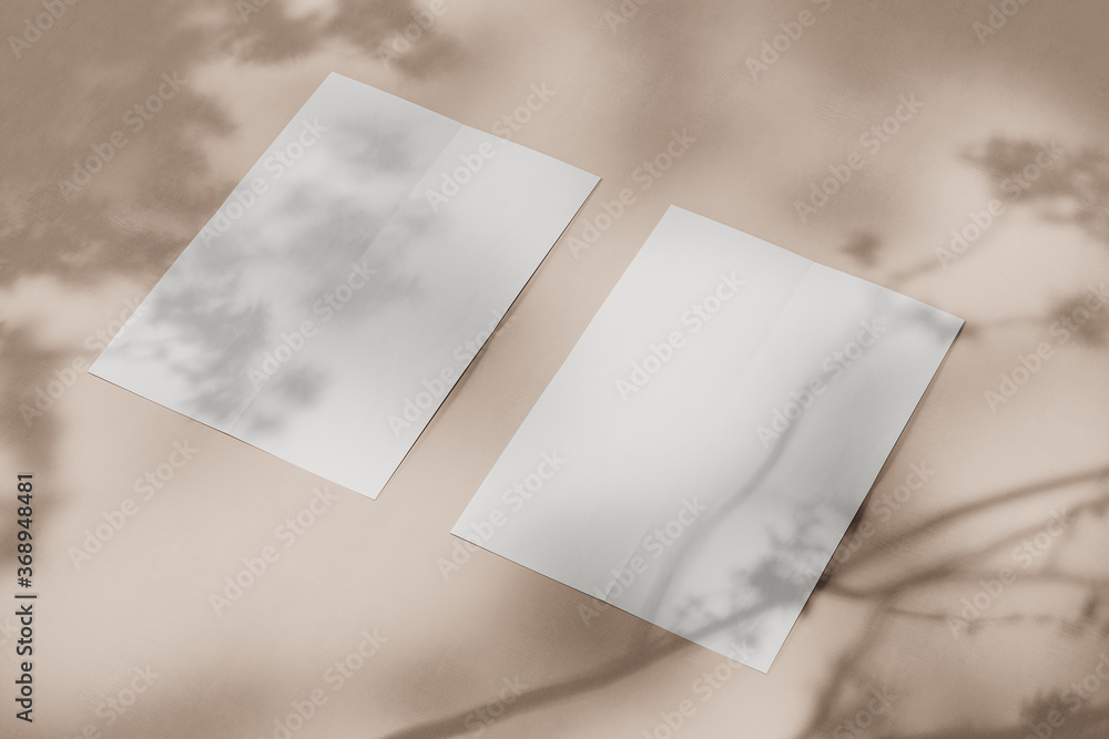 Blank vertical sheets of A4 paper on a light beige background with ...
