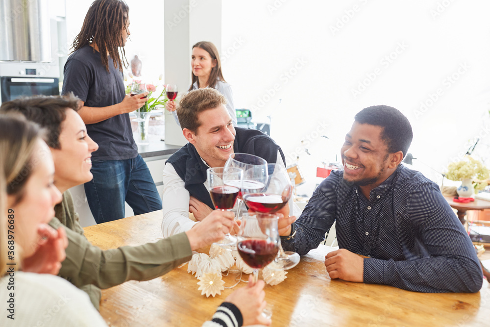 Laughing students drink wine together in shared kitchen Stock Photo ...