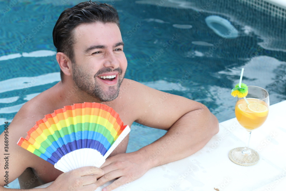 Man holding hand fan with rainbow flag in swimming pool Stock Photo ...