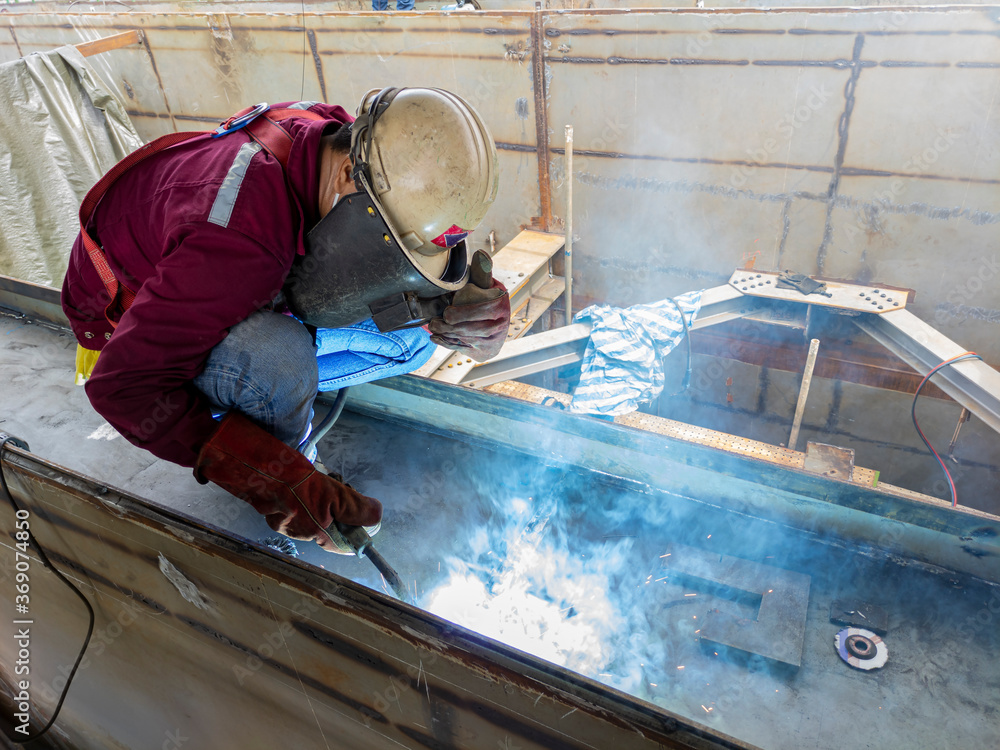 The welder is welding a steel structure work with process Flux Cored ...