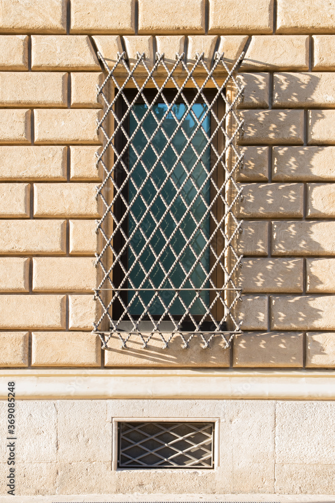 Windows are protected with metal bars on a bank building in Lecce ...