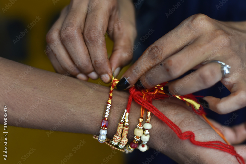 Indian sister tie a traditional rakhi in a brother hand in raksha ...